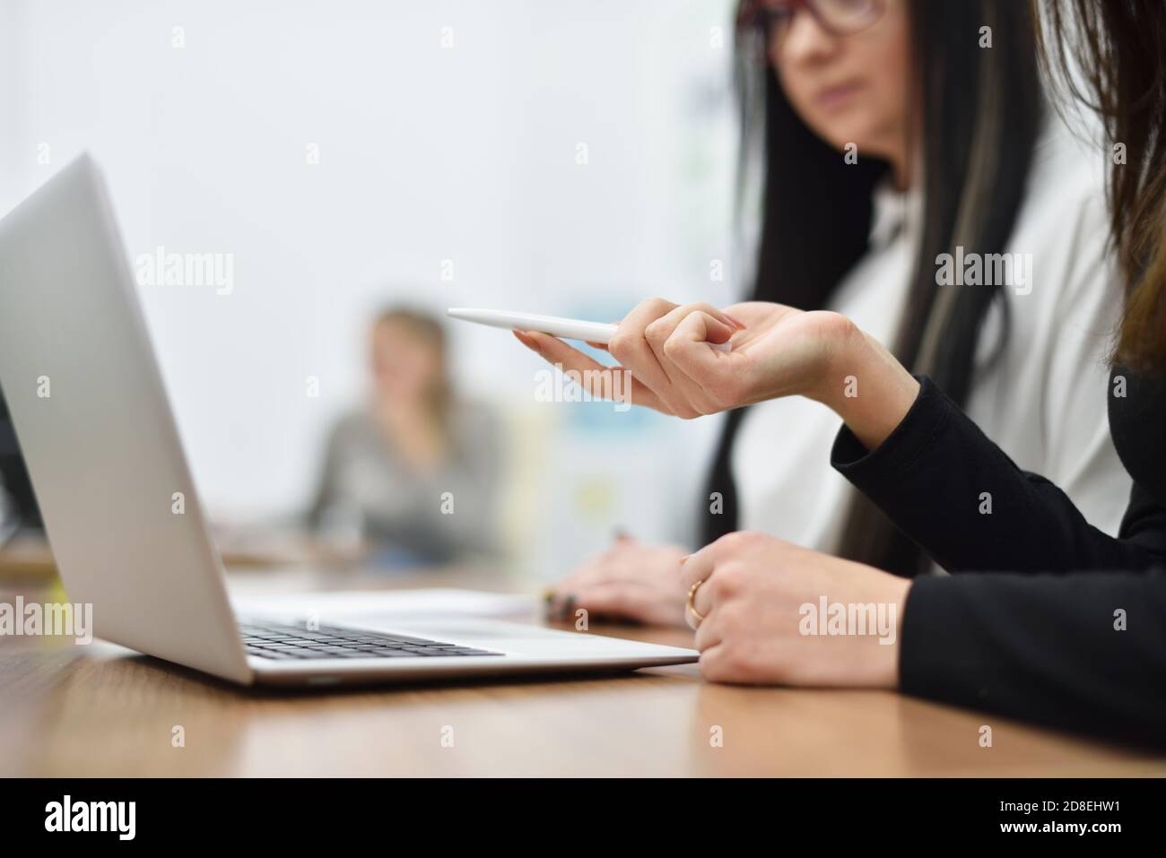 Two young female managers are working on a new project using a laptop ...