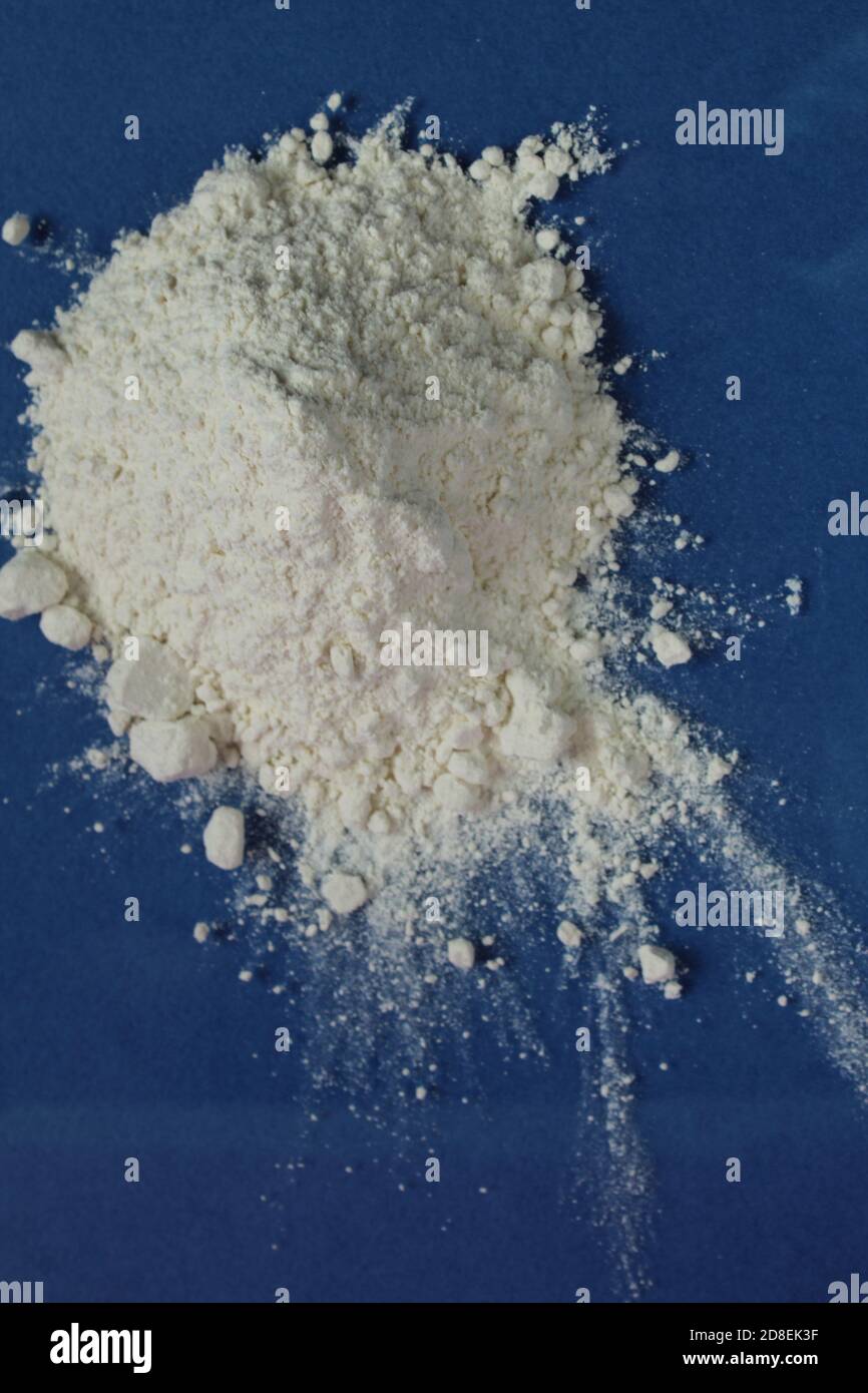 flour or powdered sugar is piled up in a pile on a bright blue ...