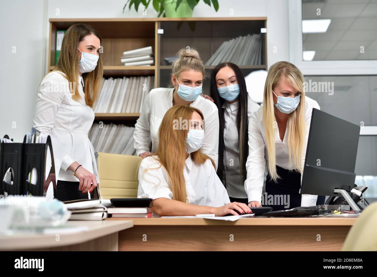 Female office managers in face masks at a meeting in the office ...