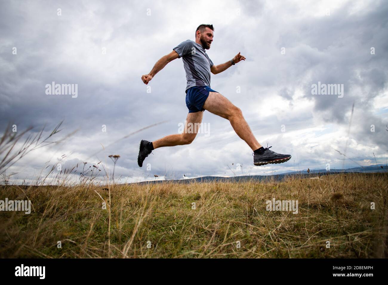 handsome trail runner running in nature Stock Photo - Alamy