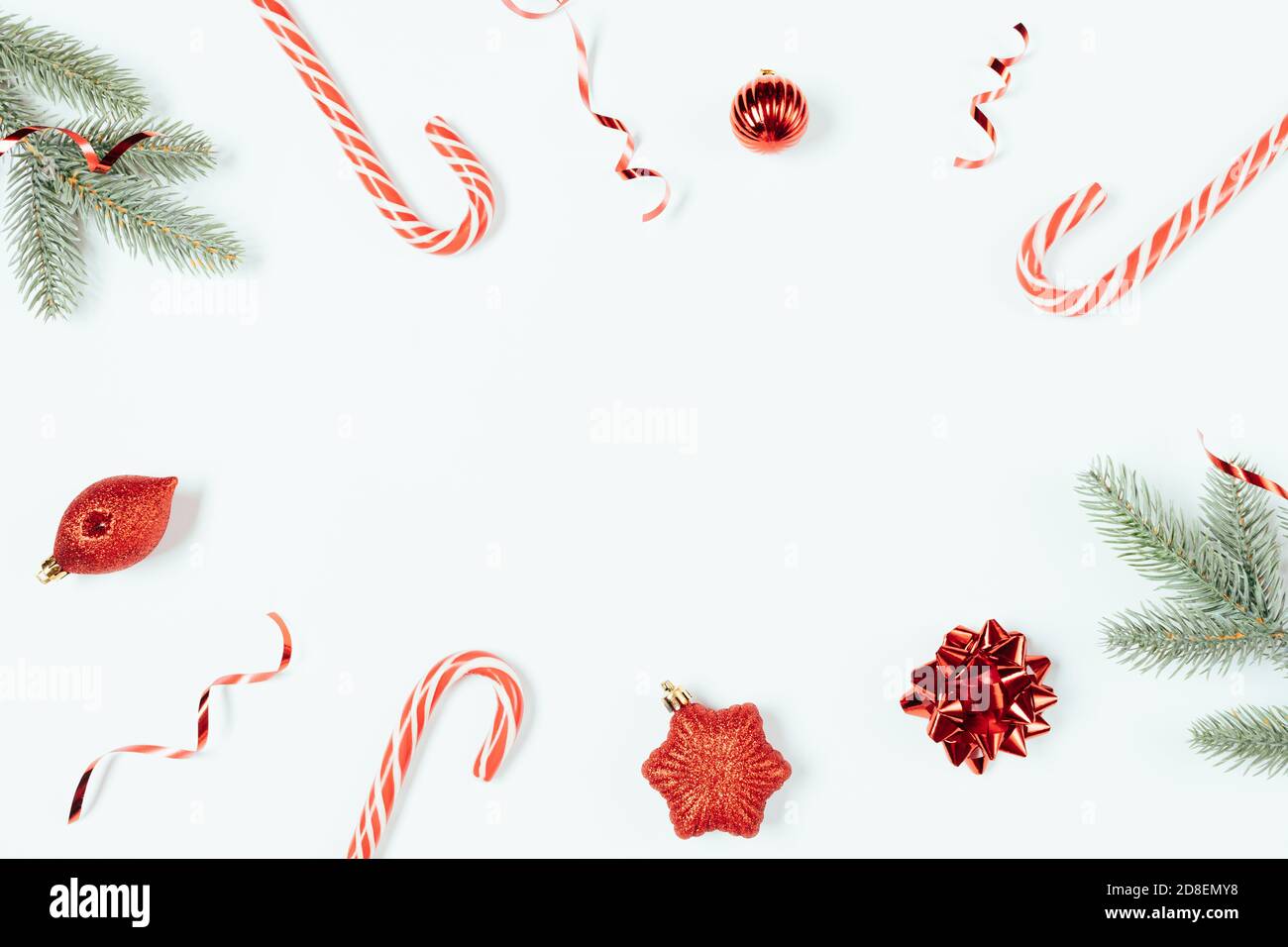 Christmas flat lay frame with candy canes, christmas tree branches and traditional red baubles ...