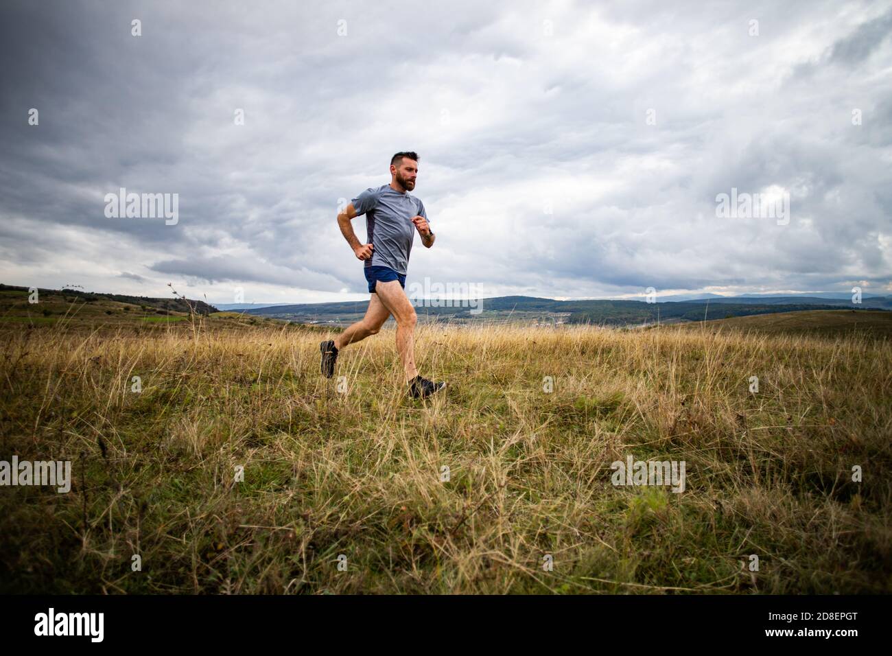 handsome trail runner running in nature Stock Photo - Alamy