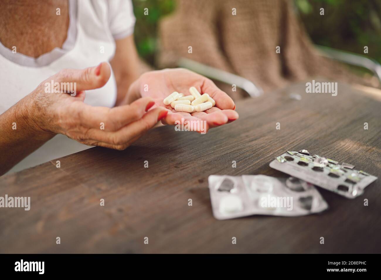 Elderly senior old woman hands holding medicine drugs vitamins pills ...
