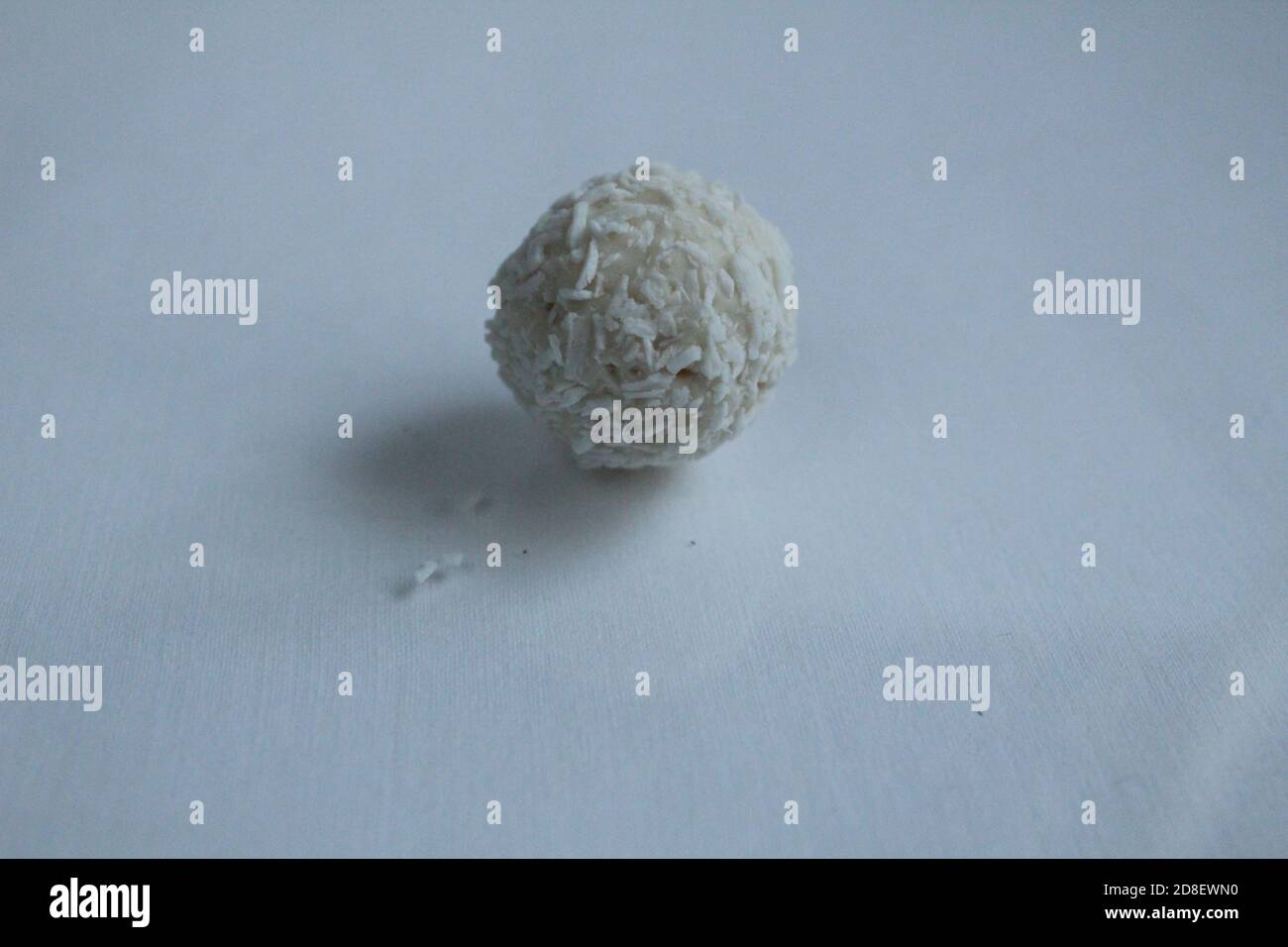 white candy in a coconut sprinkle on a white light background copy ...