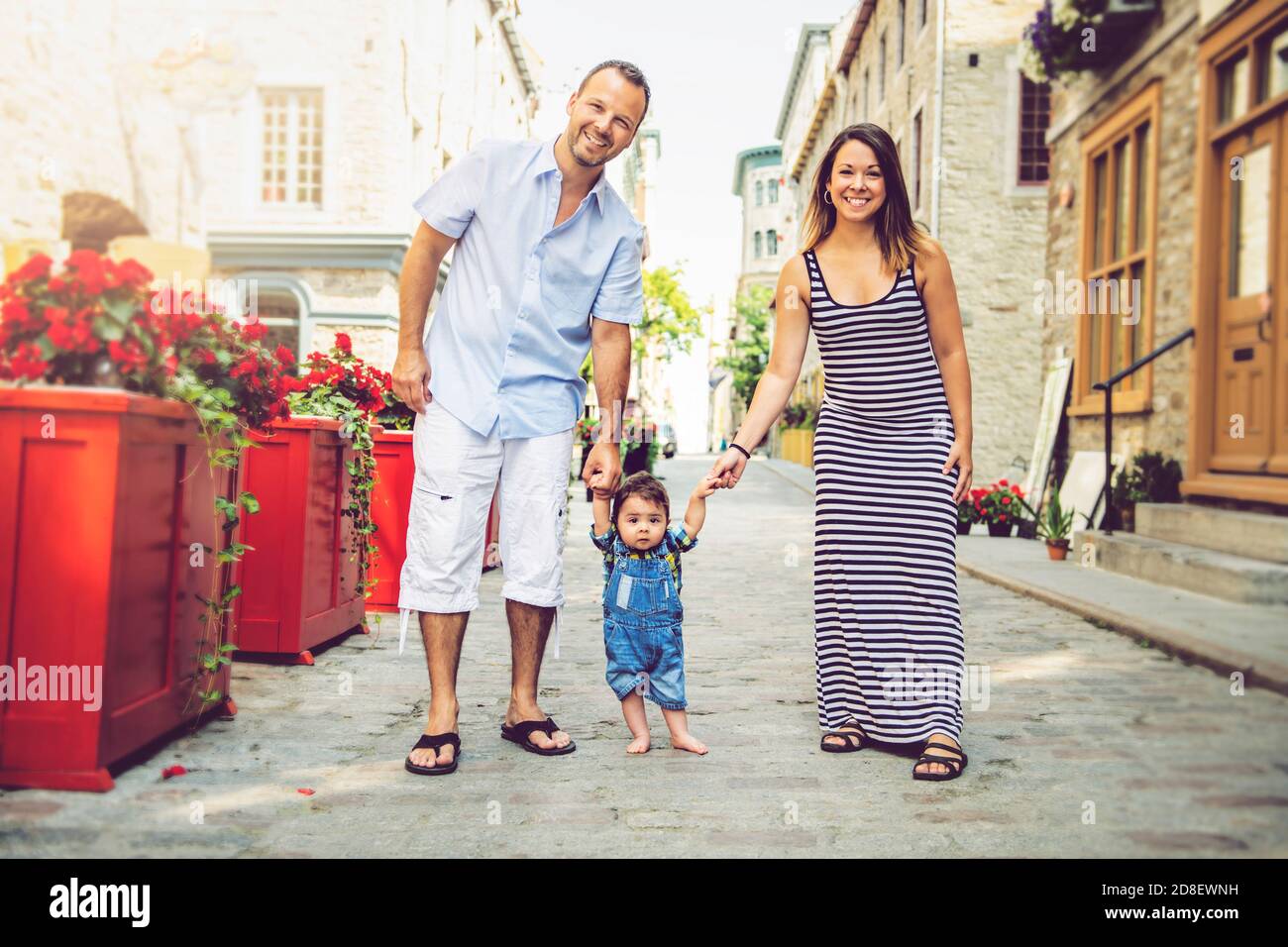 Happy family of three on the street with baby Stock Photo - Alamy