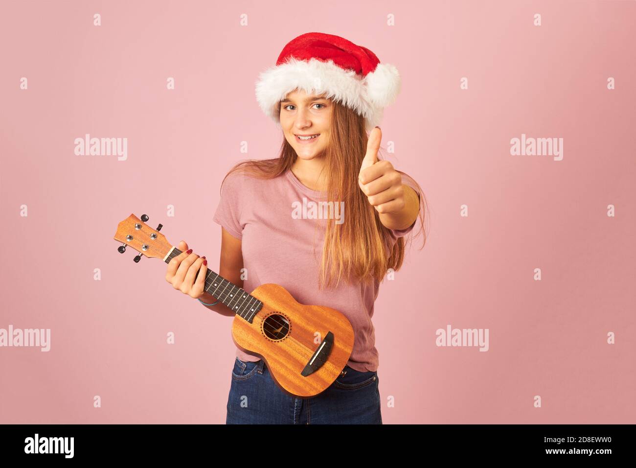 young performer woman playing ukulele and wearing Santa Claus with ...