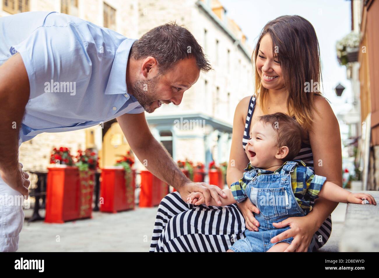 Happy family of three on the street with baby Stock Photo - Alamy