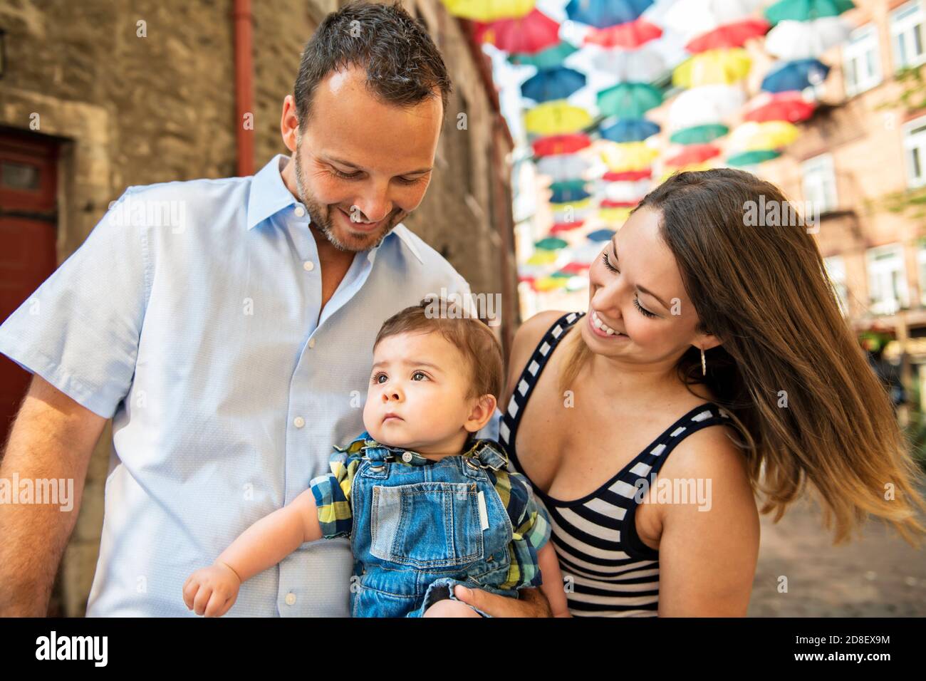 Happy family of three on the street with baby Stock Photo - Alamy