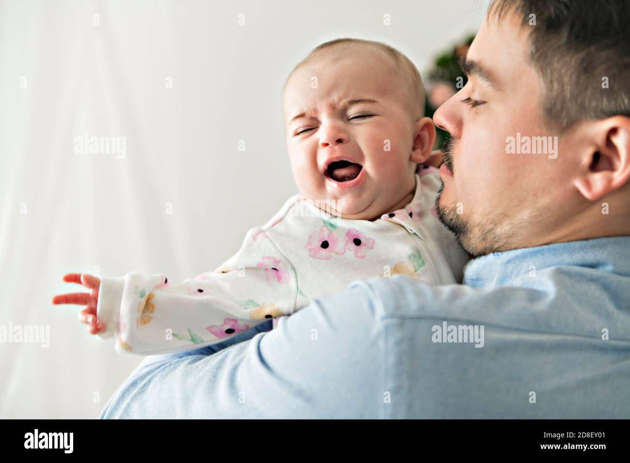 Gentle father comforting crying baby at home Stock Photo - Alamy