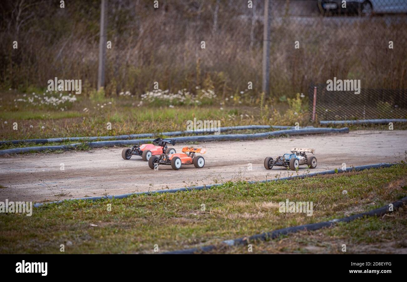 Three RC buggies racing on an outdoor offroad track Stock Photo - Alamy