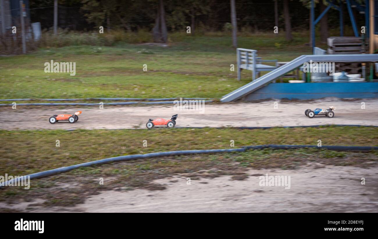 Three RC buggies racing on an outdoor offroad track Stock Photo - Alamy