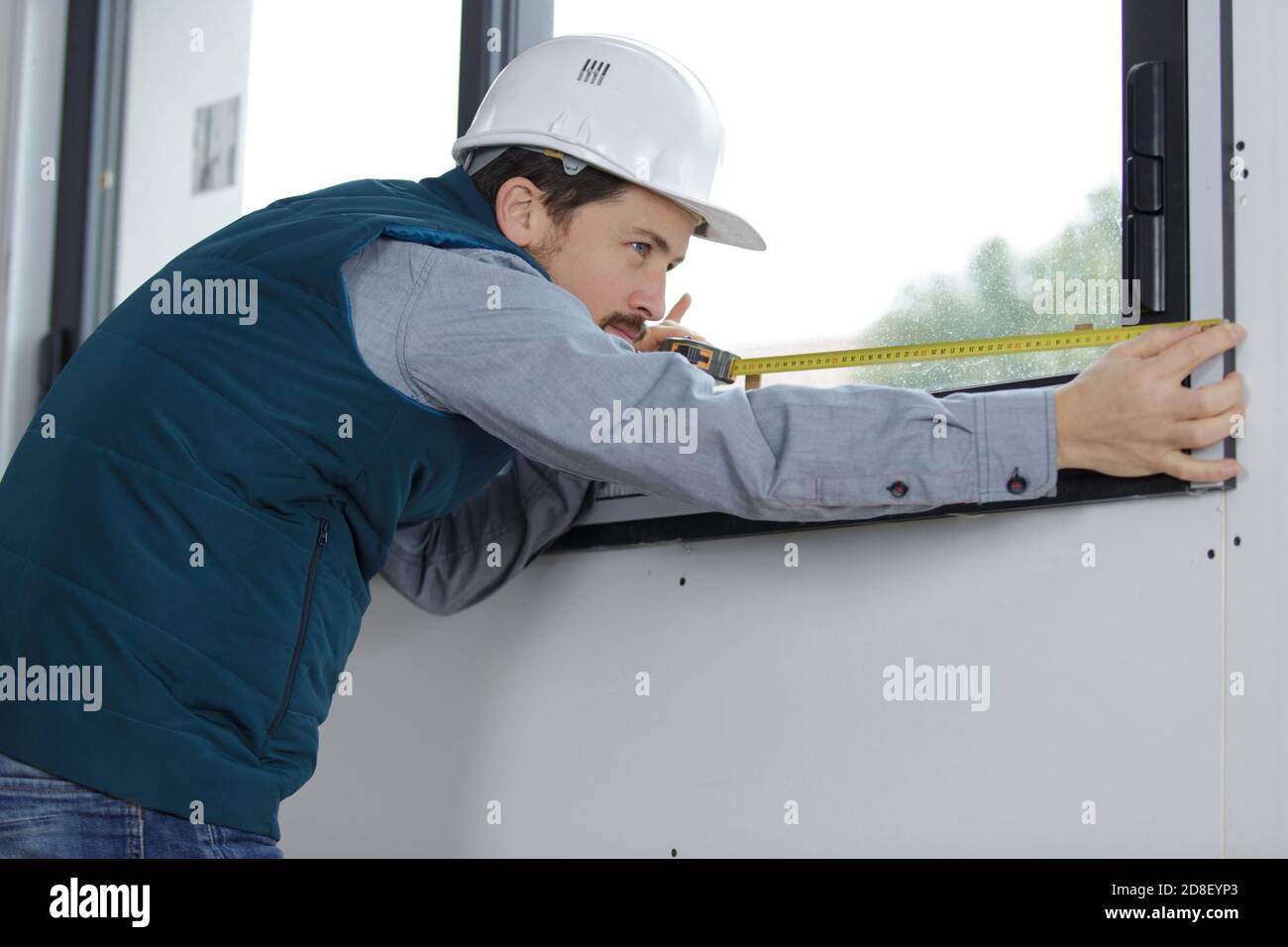 male builder is measuring window Stock Photo - Alamy