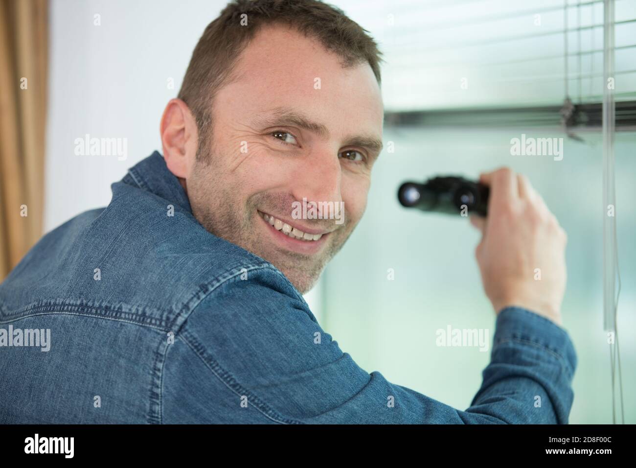 man looking with binoculars through windows Stock Photo - Alamy