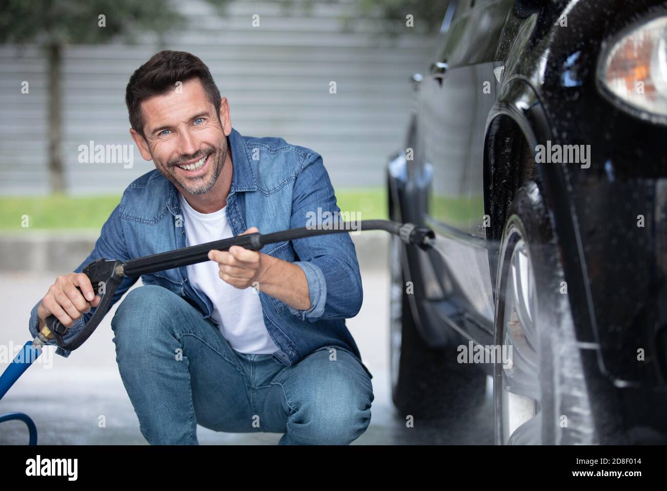 happy attractive man perfusing with water his silver car Stock Photo ...