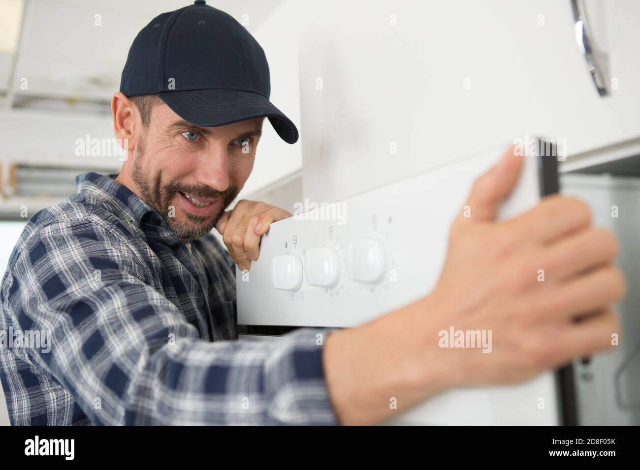 man fitting new cooker in kitchen Stock Photo - Alamy