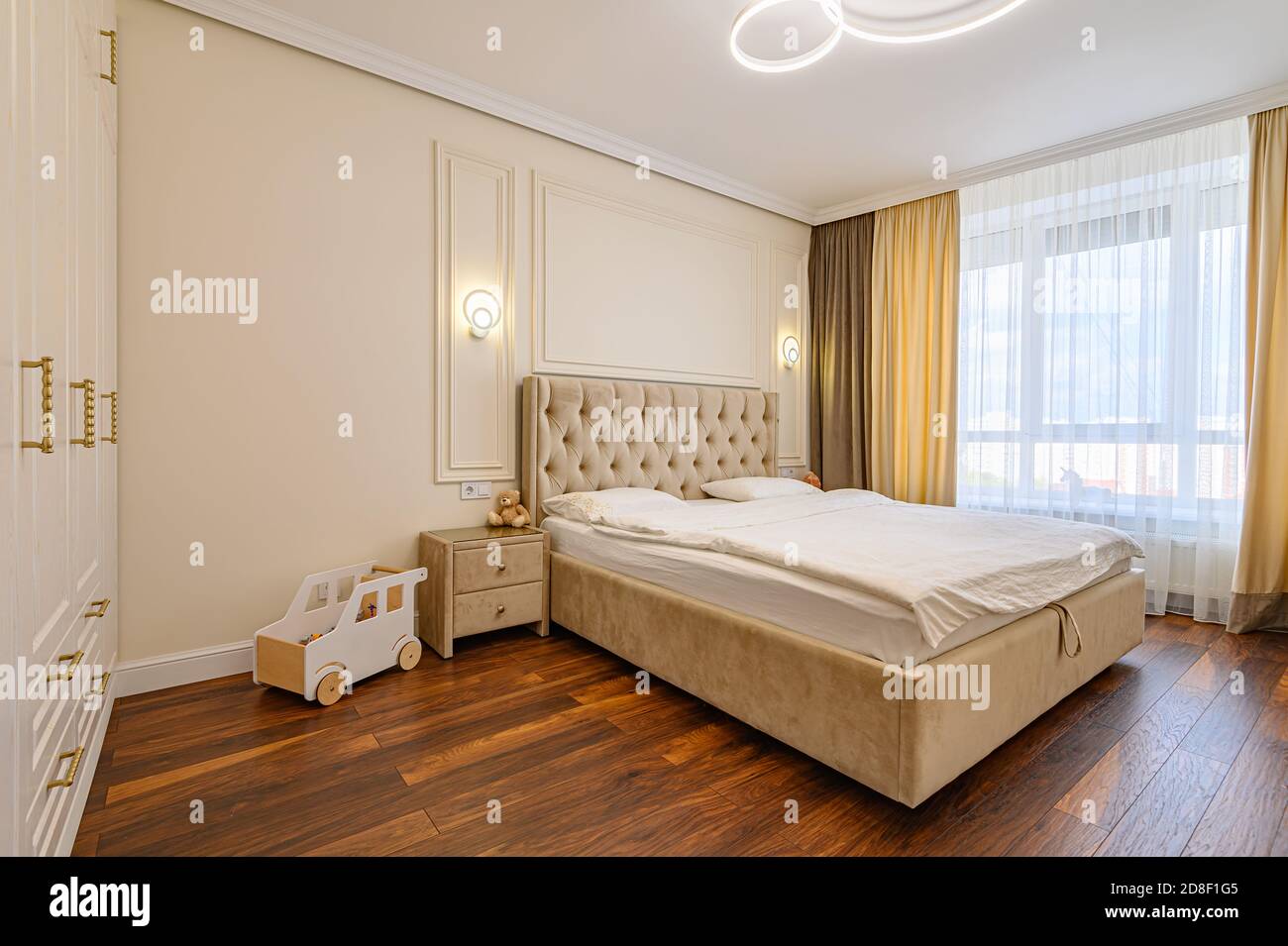 Beige colored modern bedroom interior with double bed Stock Photo - Alamy