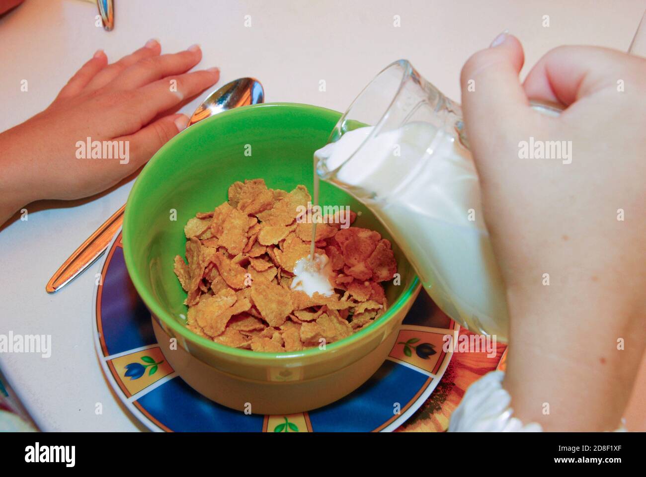 kid is having corn flakes in a bowl with milk for breakfast Stock Photo ...