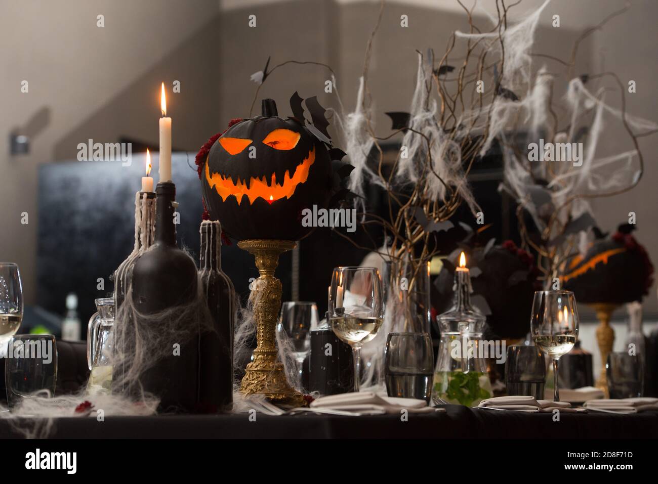 Table set for Halloween dinner. Served holiday table with candles and ...
