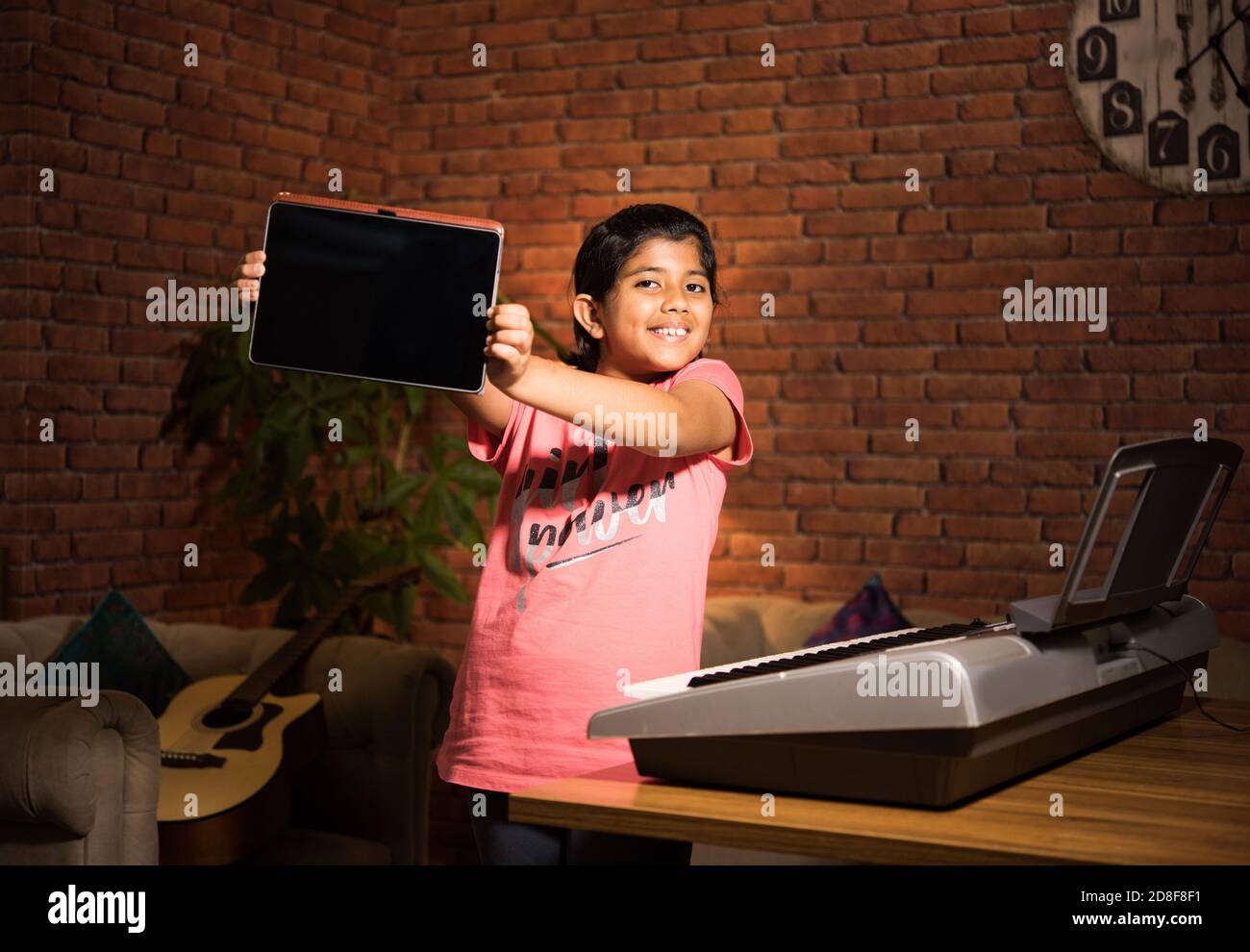 Asian Indian child learning music or musical instrument online using ...