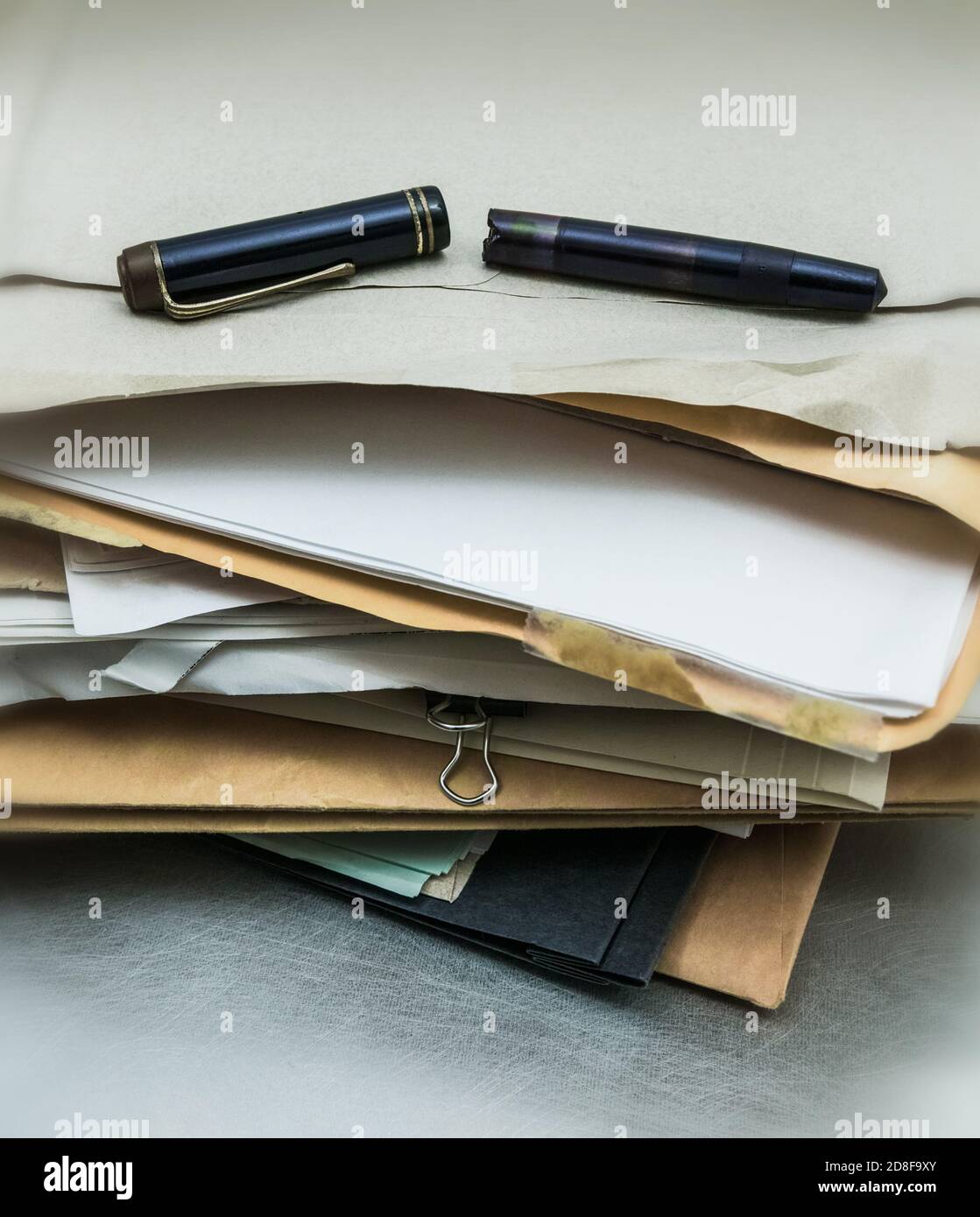 On a pile of documents, a fountain pen is broken Stock Photo - Alamy