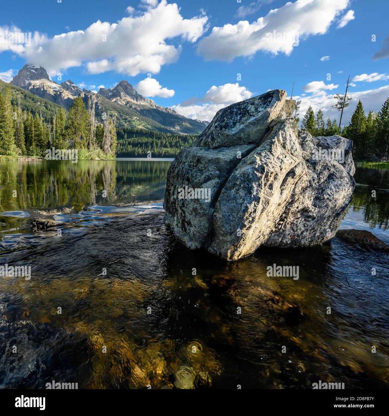 Large Boulder in Taggart Lake with smooth water Stock Photo - Alamy