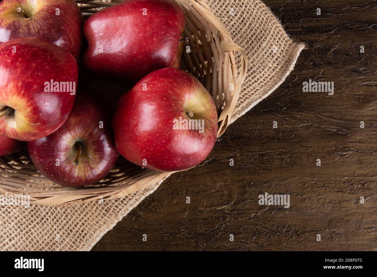 Red apples in basket with wooden background Stock Photo - Alamy