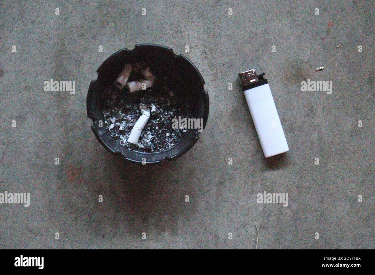 Extinguished cigarettes with ash tray and white lighter Stock Photo - Alamy