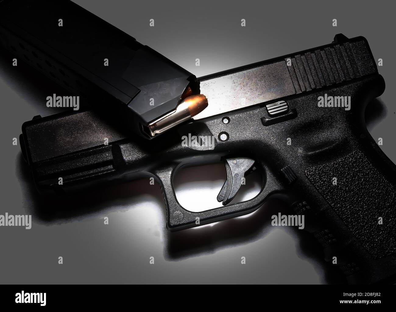 A semi automatic black 9mm pistol with a loaded pistol magazine laying ...