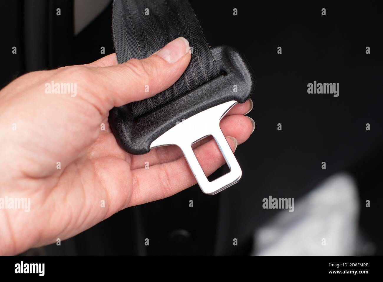 Close up of a woman's hand fastening seat belt while sitting inside a ...