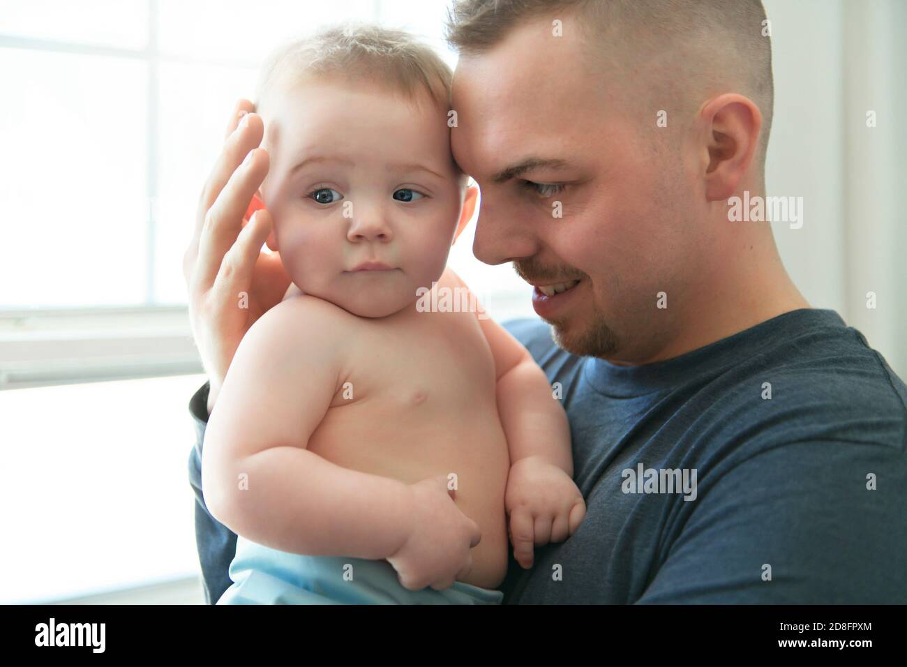 the father hugging her baby with a sad face and eyes Stock Photo - Alamy