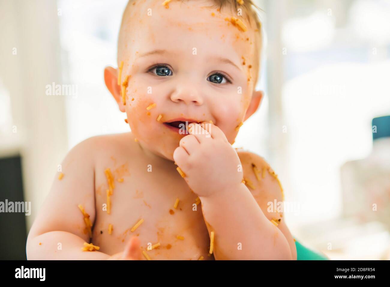 Little baby boy eating her dinner and making a mess Stock Photo - Alamy