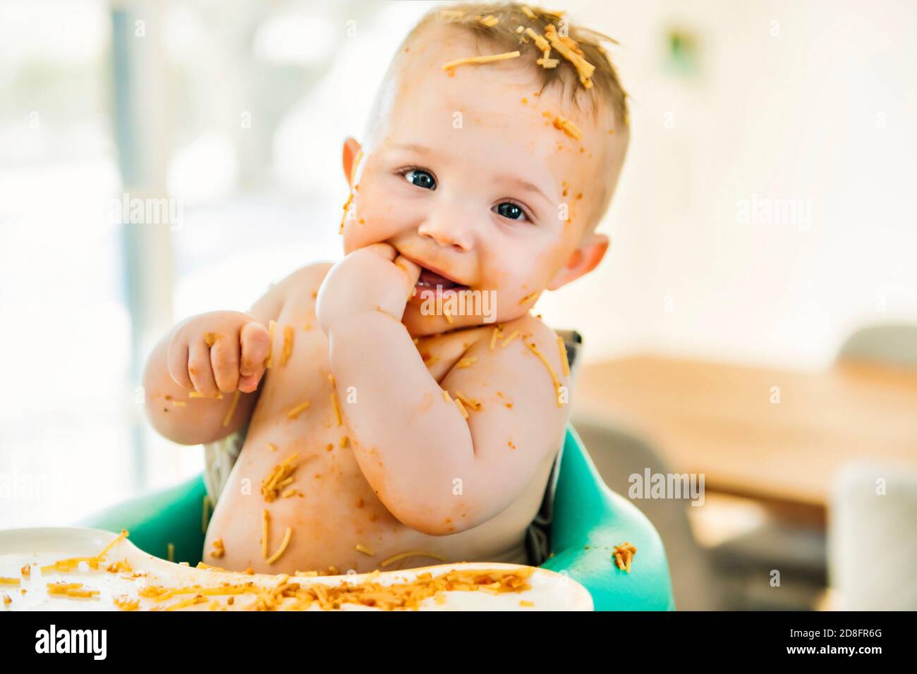 Little baby boy eating her dinner and making a mess Stock Photo - Alamy