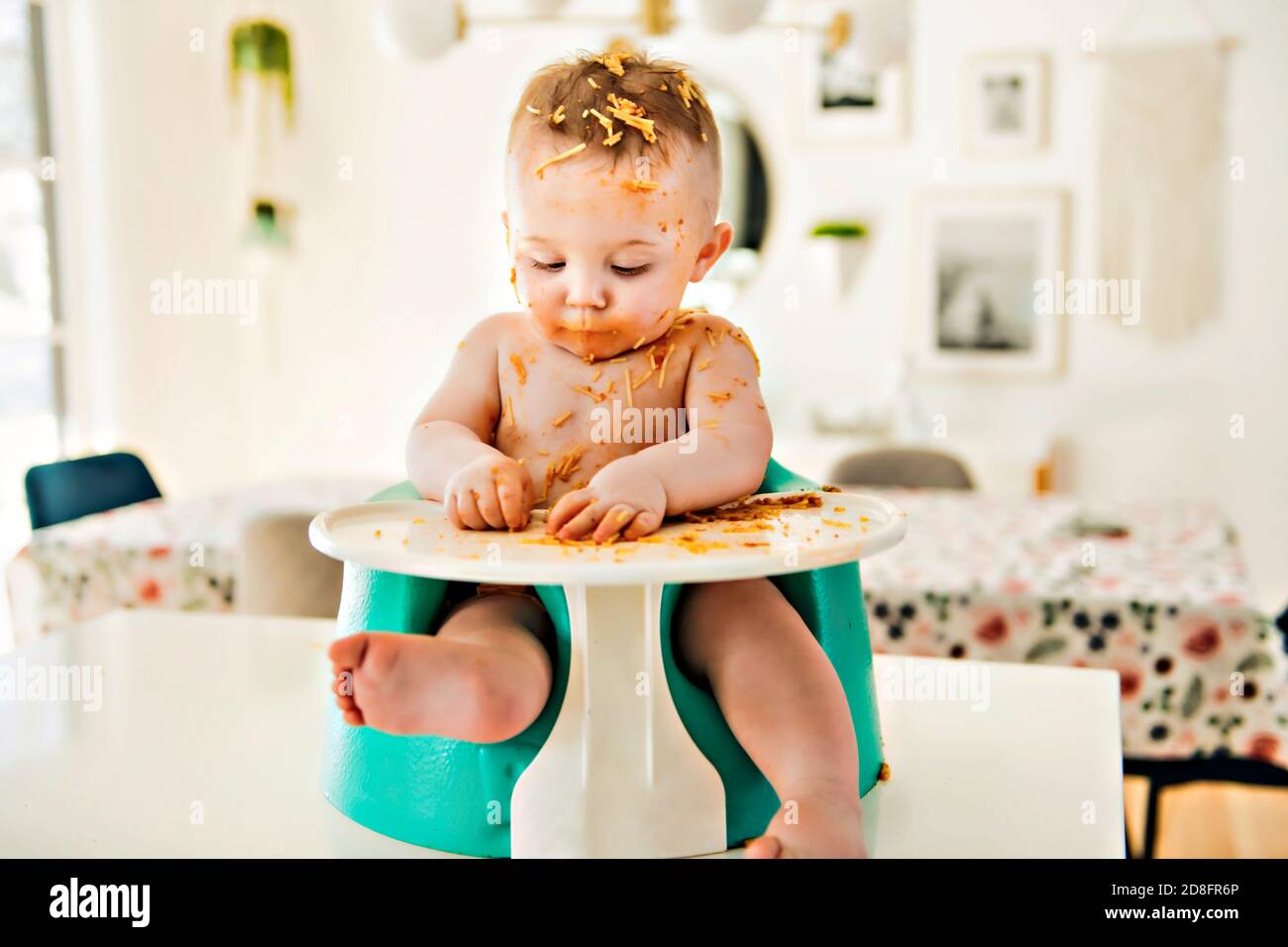 Little baby boy eating her dinner and making a mess Stock Photo - Alamy