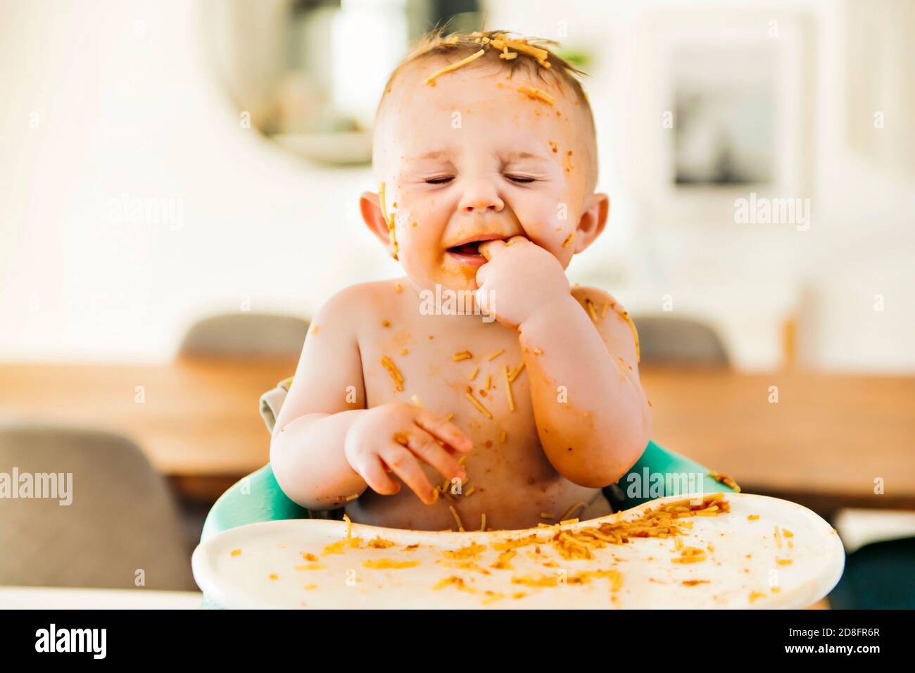 Little baby boy eating her dinner and making a mess Stock Photo - Alamy