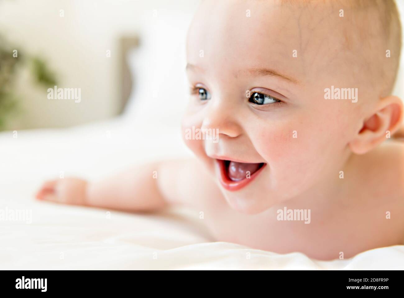 cute baby boy lying on a white bed Stock Photo - Alamy