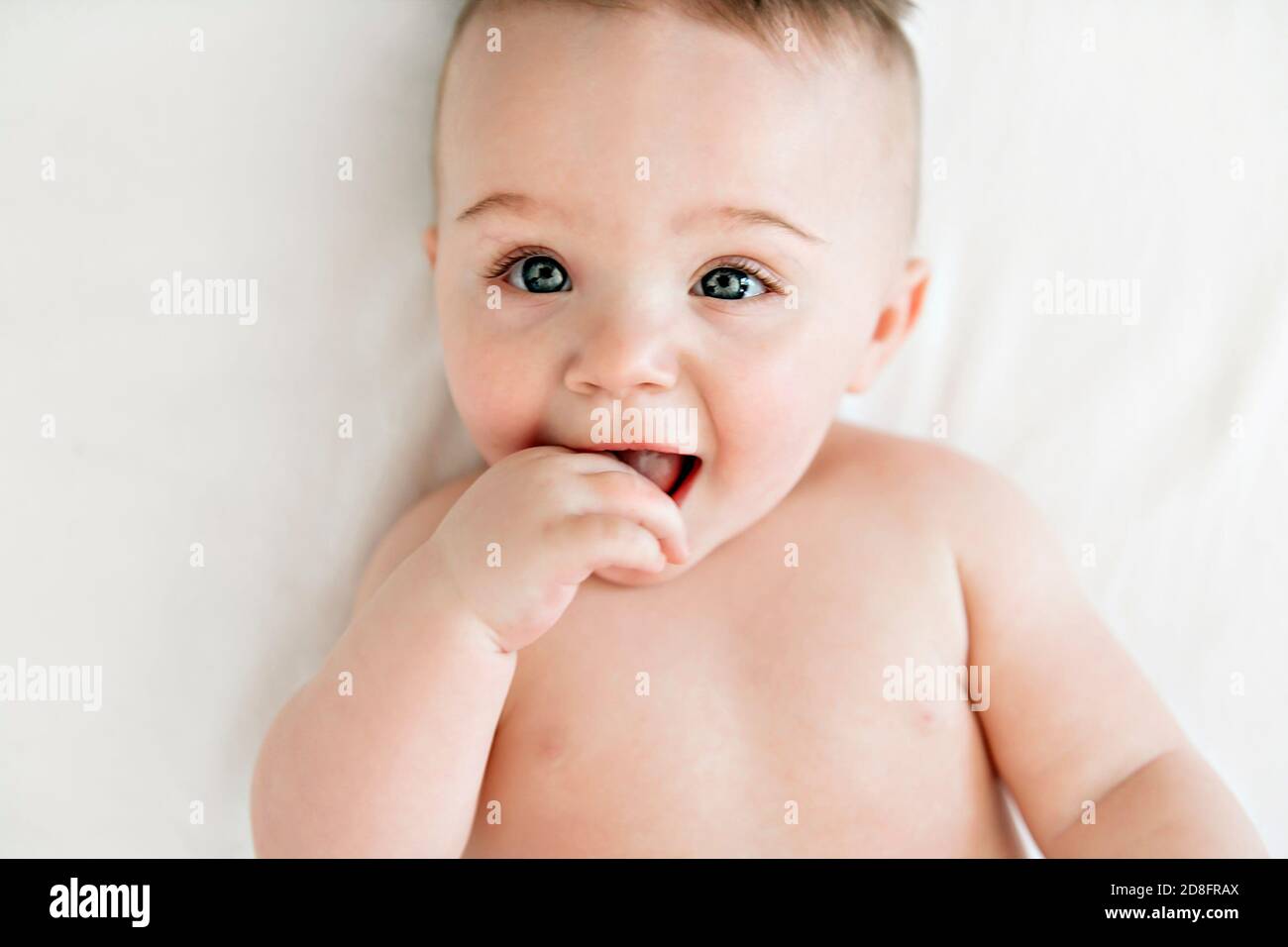 cute baby boy lying on a white bed Stock Photo - Alamy