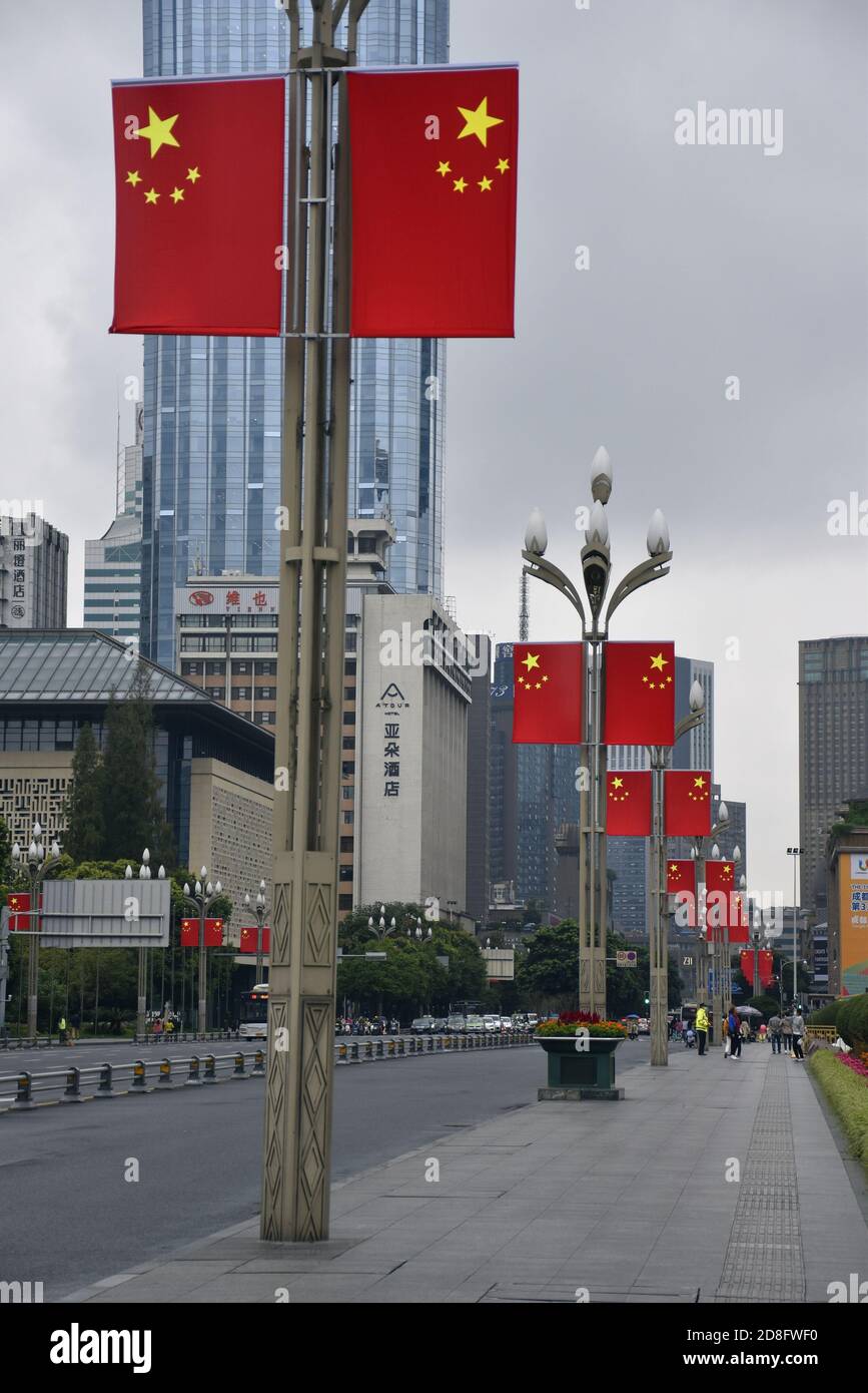 National flags fly on the street, under which vehicles and pedestrians ...