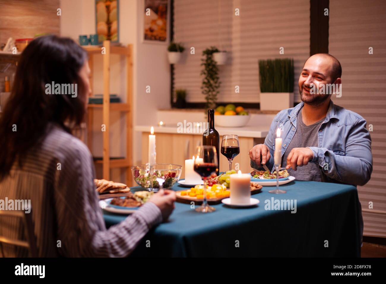 Lovers enjoying tasty food while having dinner in kitchen. Relax happy ...