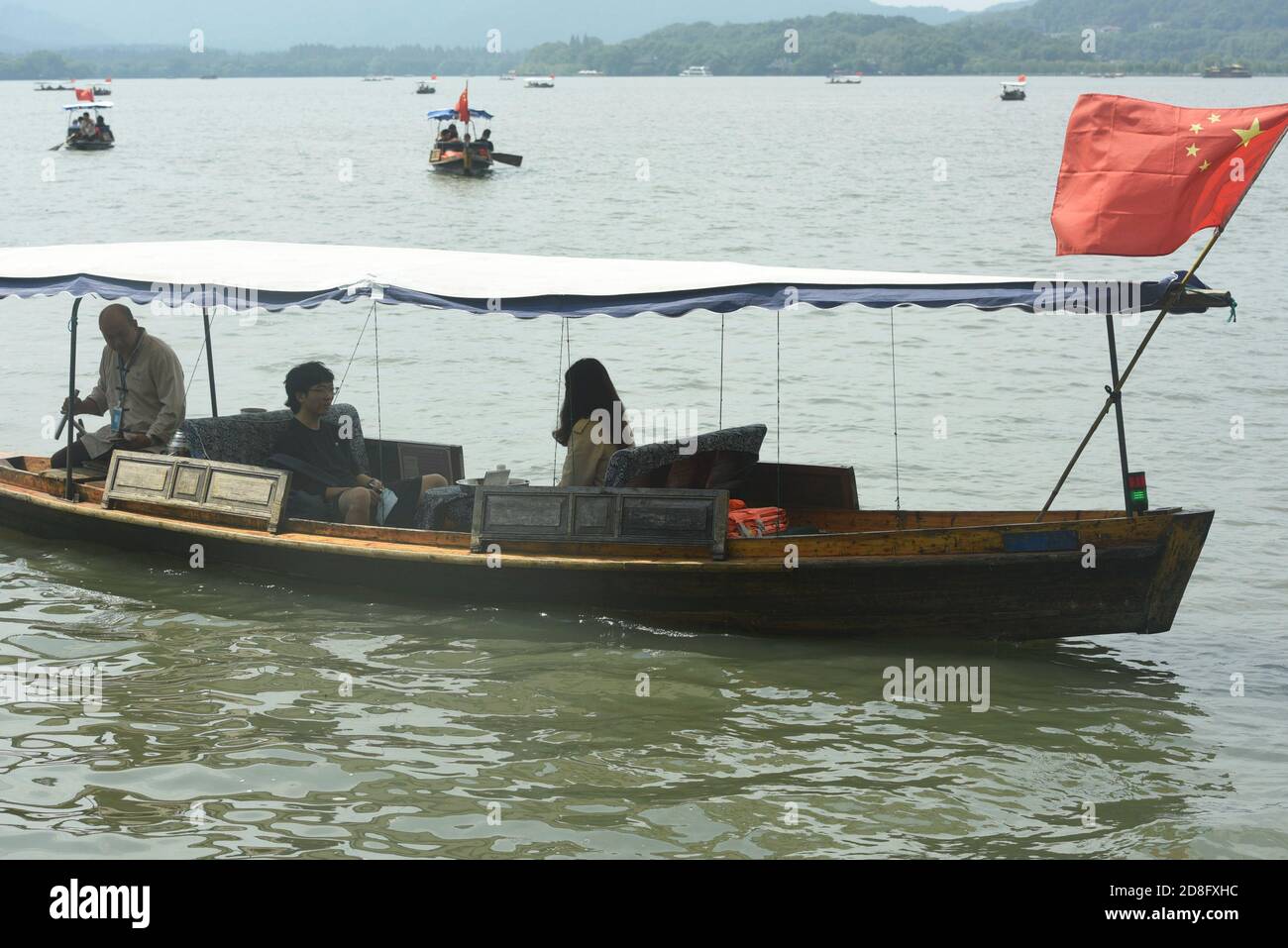 National flags of China fly on the boat in the West Lake, welcoming the ...