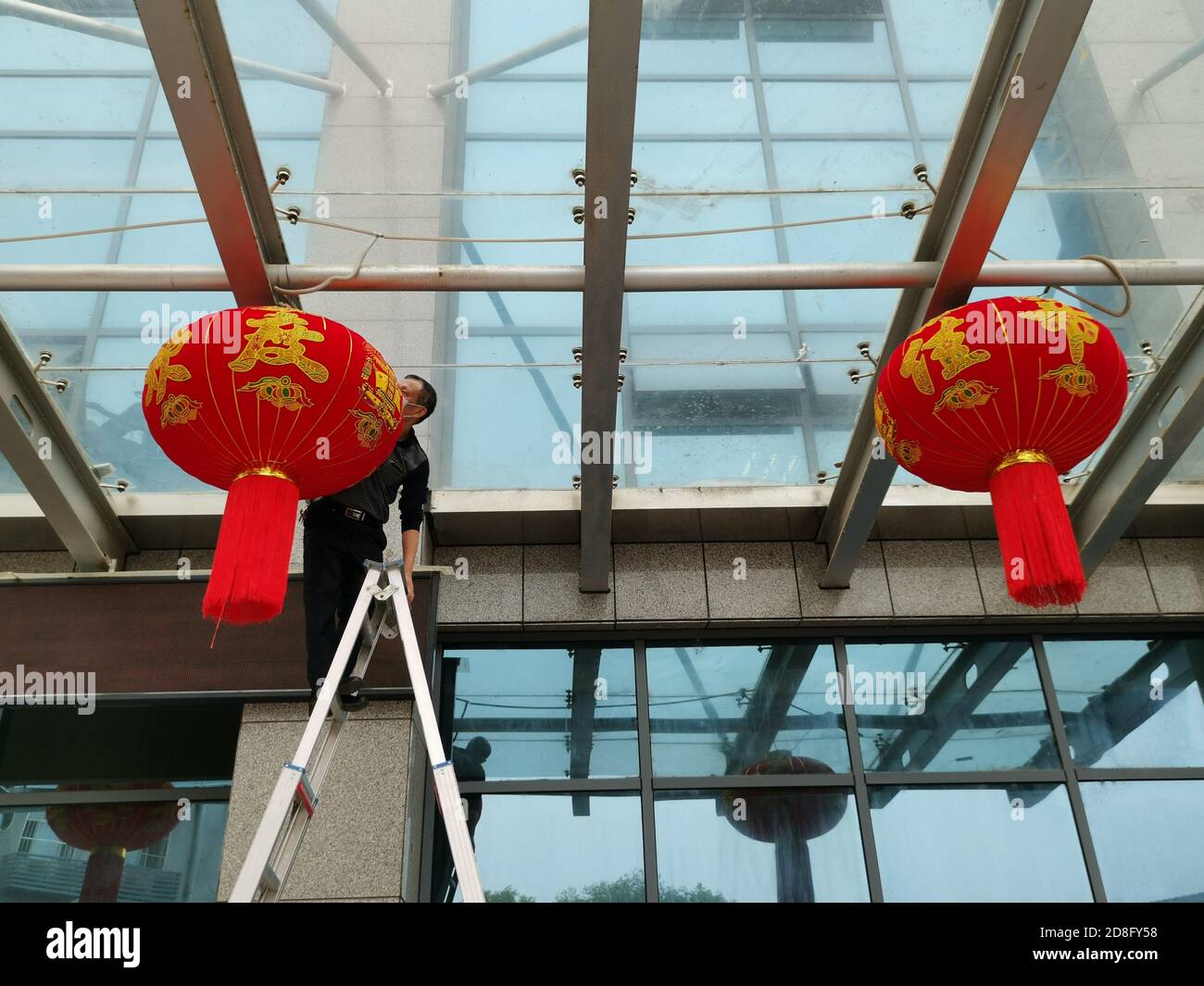 Red lanterns and national flags are seen flying along the Yihe street ...