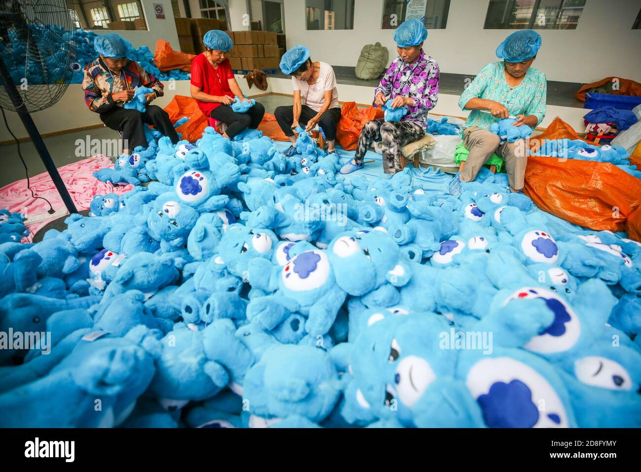 Workers are busy with the production in a large doll factory in Ankang ...