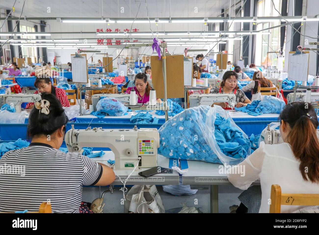 Workers are busy with the production in a large doll factory in Ankang ...