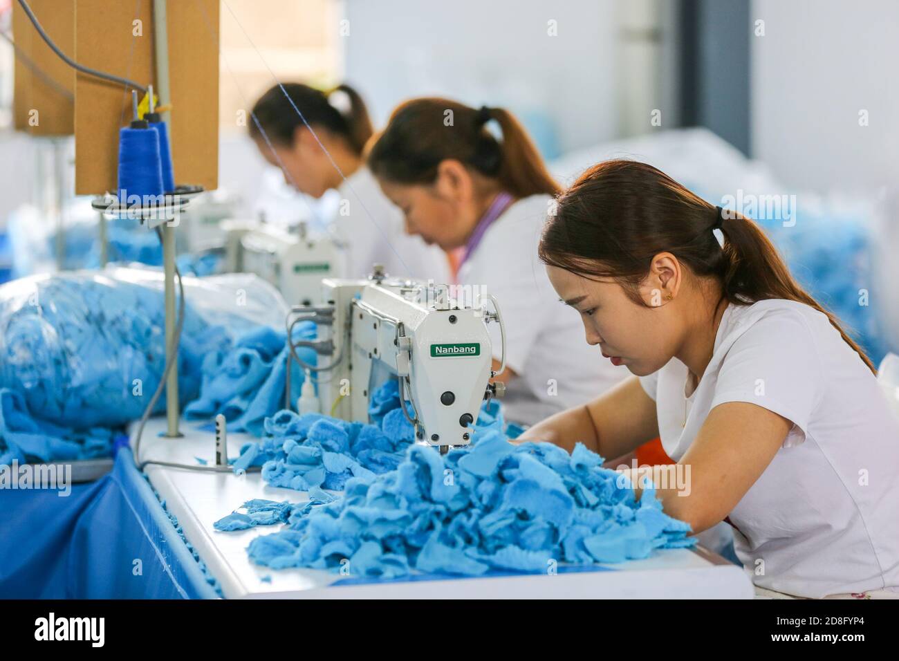 Workers are busy with the production in a large doll factory in Ankang ...