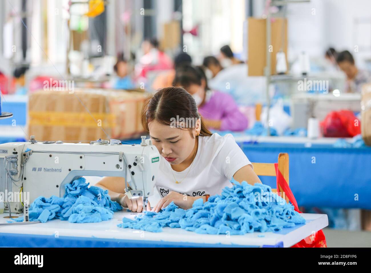 Workers are busy with the production in a large doll factory in Ankang ...