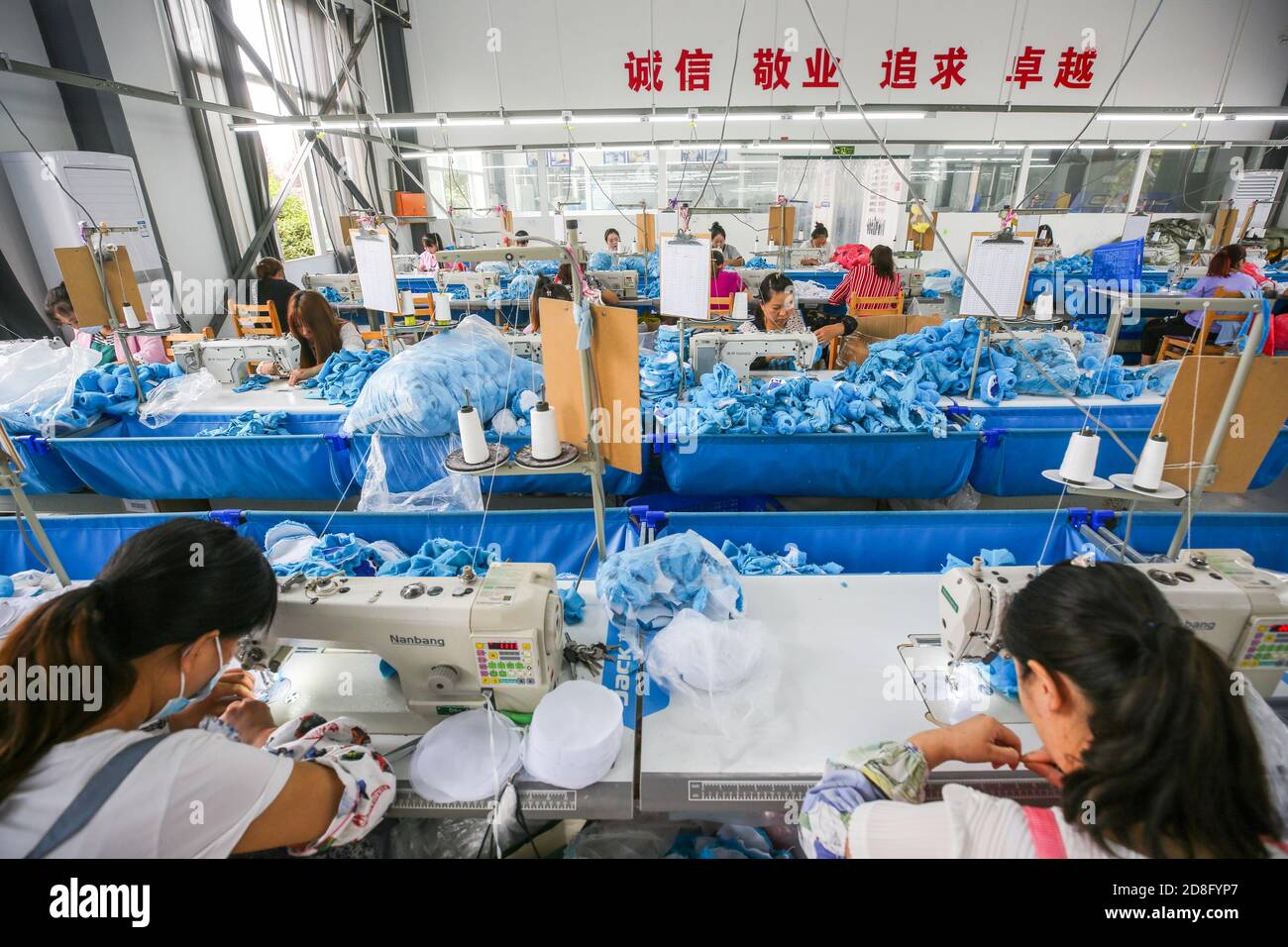 Workers are busy with the production in a large doll factory in Ankang ...