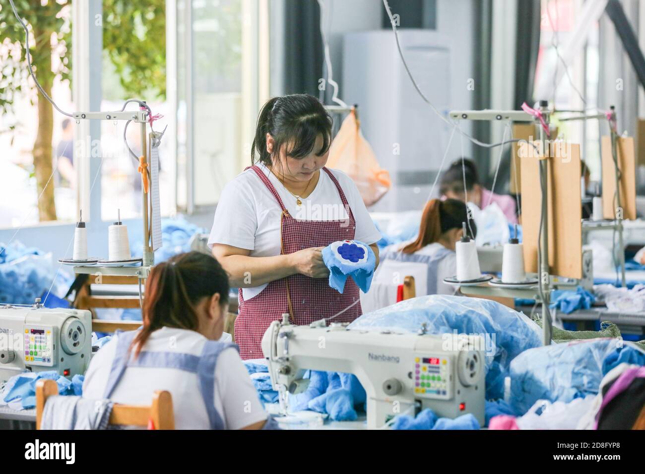 Workers are busy with the production in a large doll factory in Ankang ...