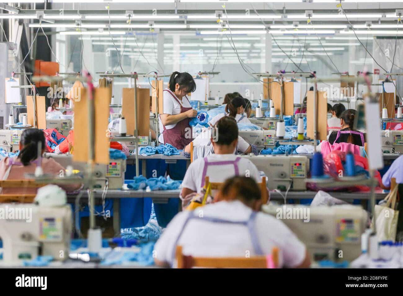Workers are busy with the production in a large doll factory in Ankang ...