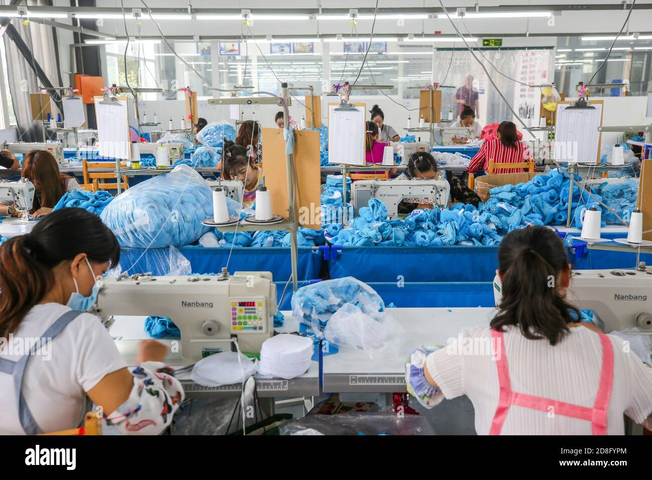 Workers are busy with the production in a large doll factory in Ankang ...