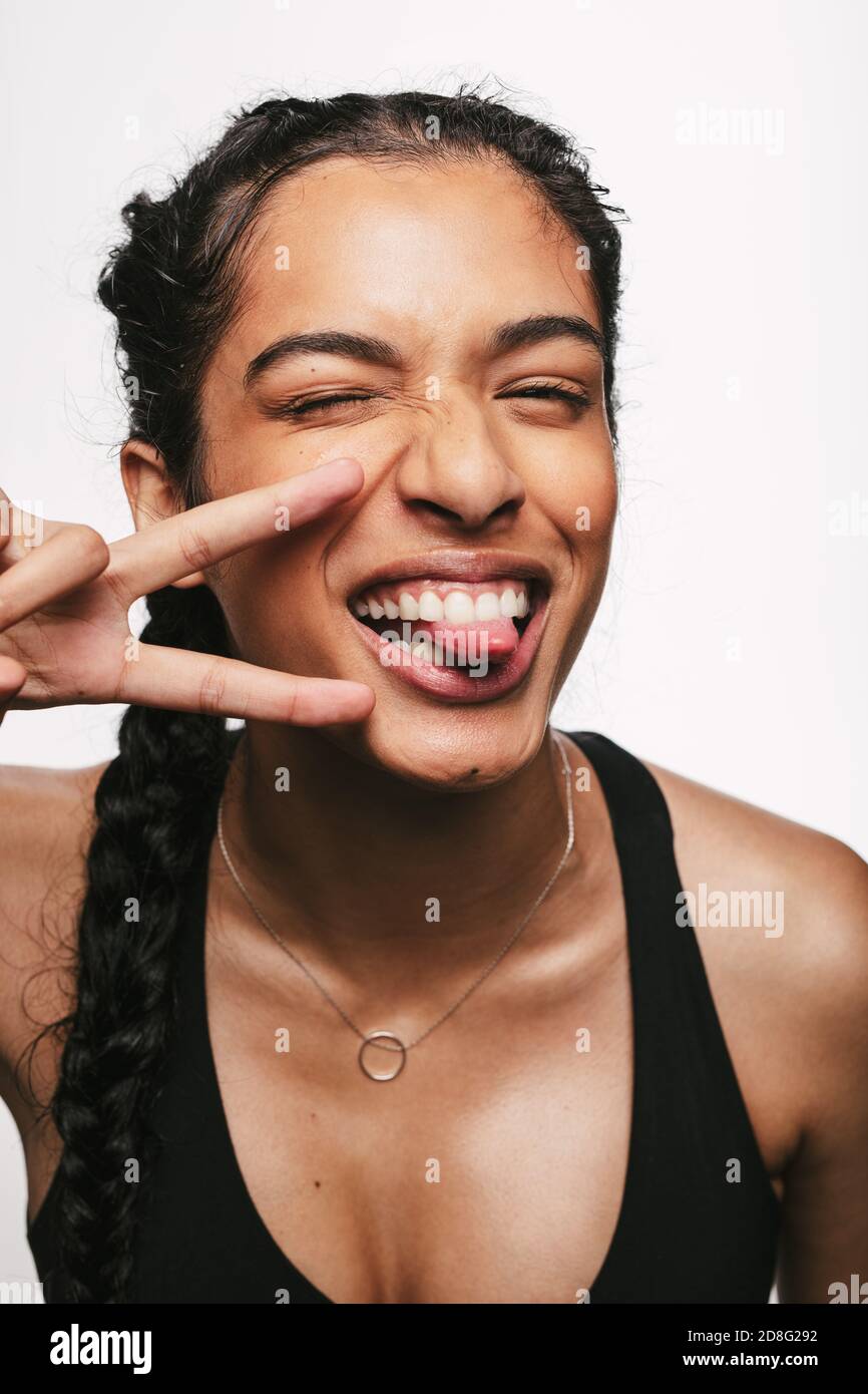 Cheerful fitness woman having fun making faces. Close up portrait of ...