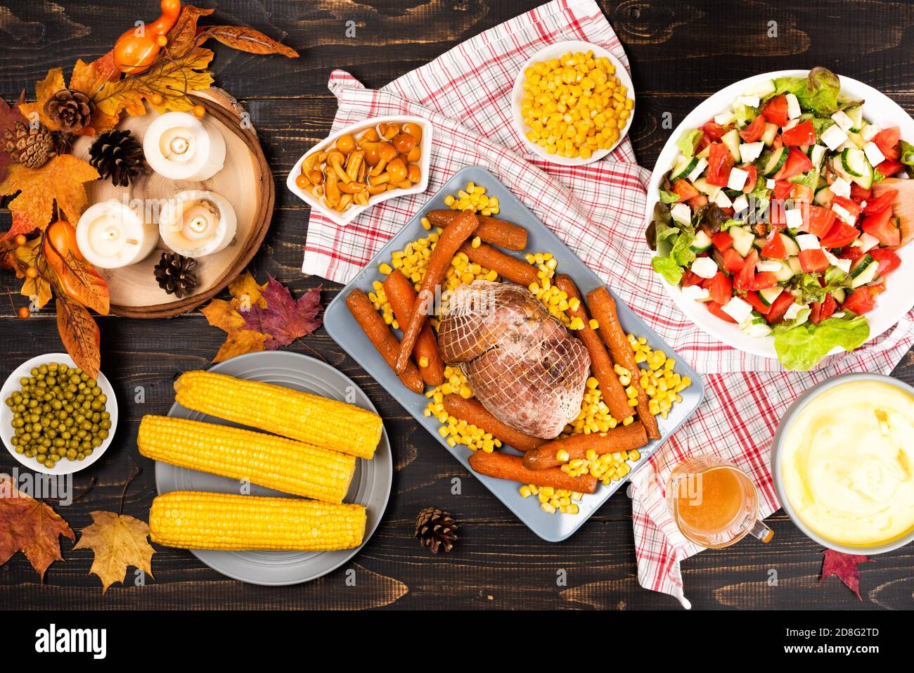 Festive autumn holiday table setting with boiled pork, corn, mashed ...